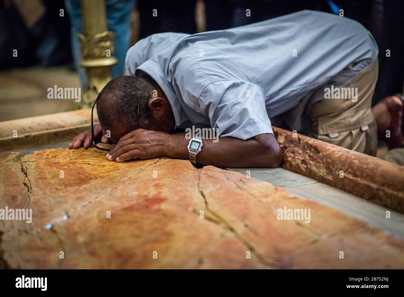A man prays on the stone of anointing in the Church of the Holy ...