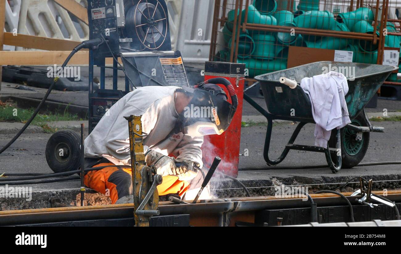 A worker is welding on a rail of the Berlin tram network. [automated ...