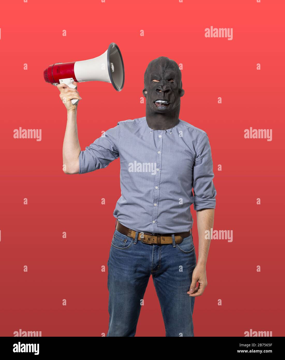Male in a black angry mask holding a megaphone on a red background ...