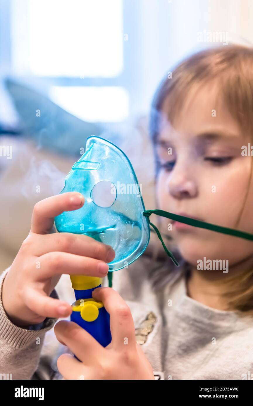 Cute baby girl breathes through nebulizer inhaler virus treatment ...