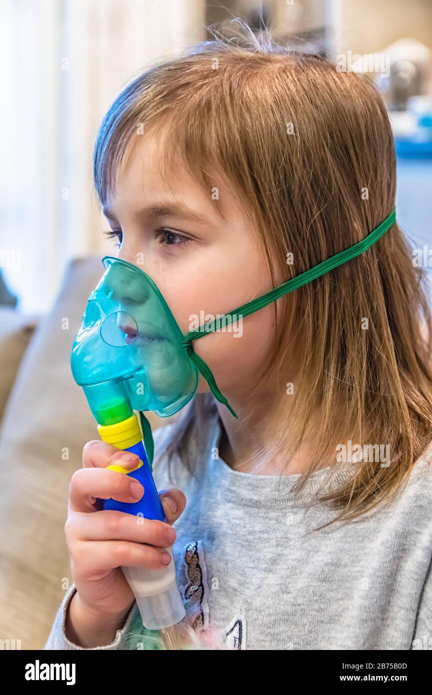 Cute baby girl breathes through nebulizer inhaler Stock Photo - Alamy