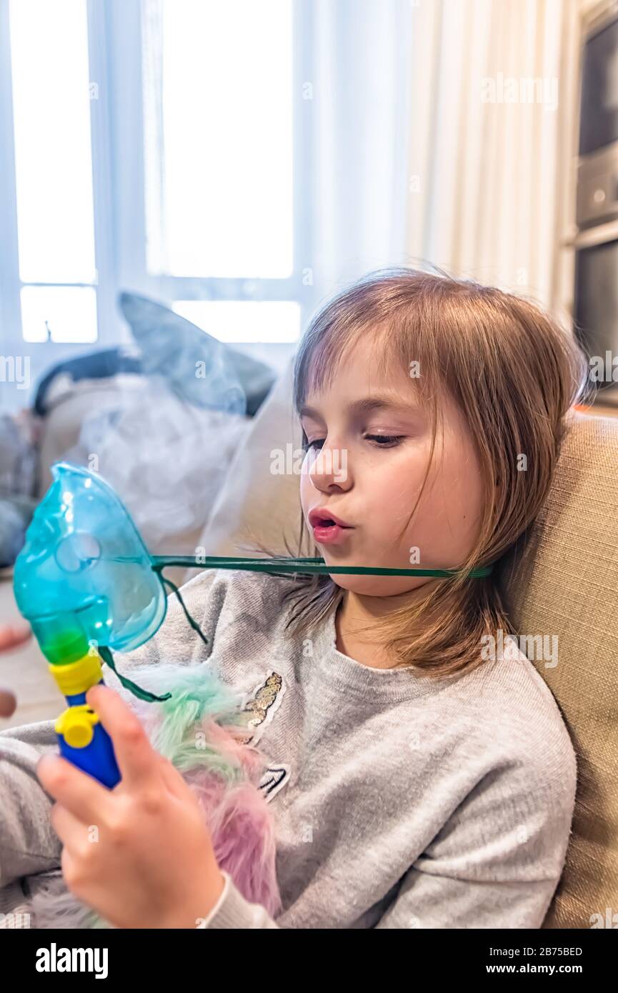 Cute baby girl breathes through nebulizer inhaler virus treatment ...