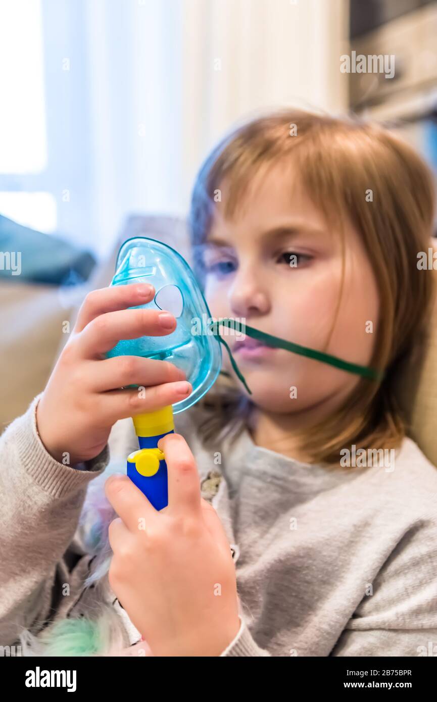 Cute baby girl breathes through nebulizer inhaler Stock Photo - Alamy
