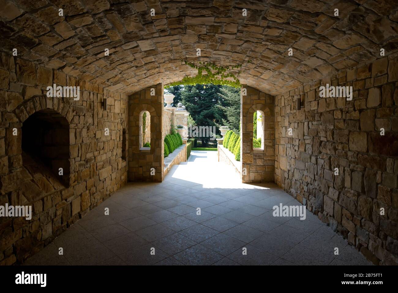 Modern garden design with a stone tunnel leading to a garden path ...