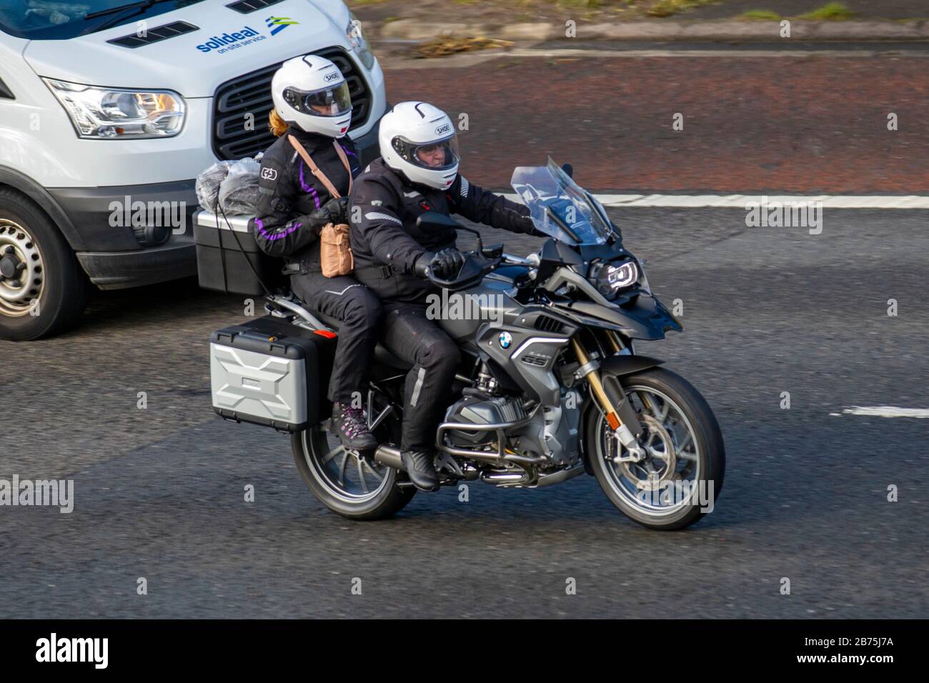 Silver BMW motorcycle rider; Vehicular traffic, two wheeled transport ...