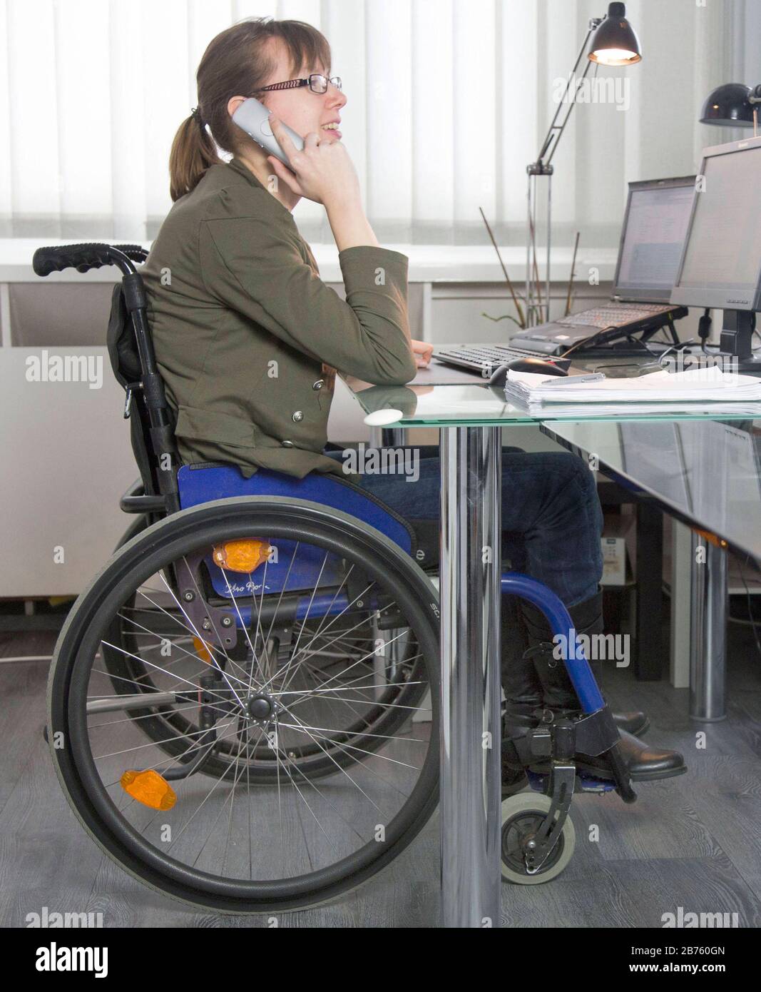 Young disabled woman in wheelchair on 18.01.2017 at her computer ...