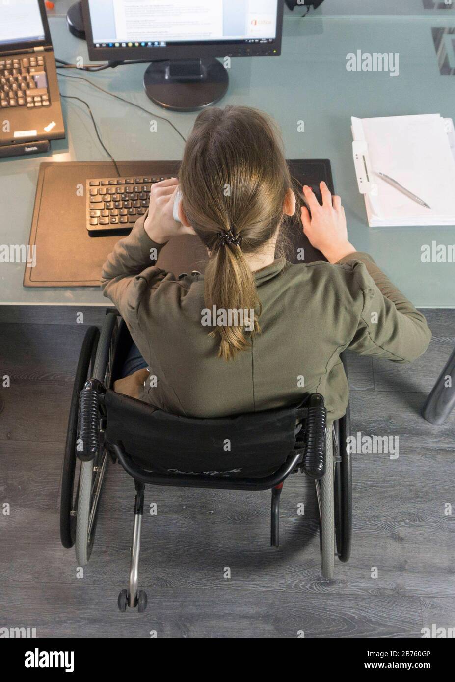 Young disabled woman in wheelchair on 18.01.2017 at her computer ...