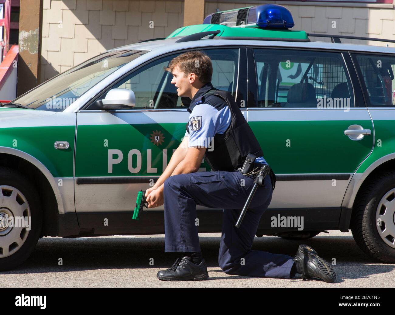 With a green practice pistol in his hand, a policeman of the Berlin ...