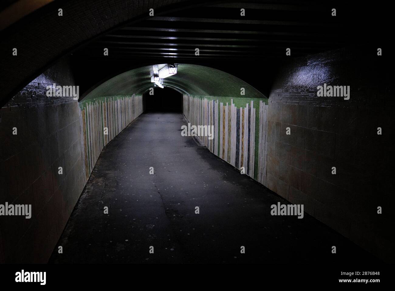 Badly lit pedestrian underpass at night, intimidating urban environment ...