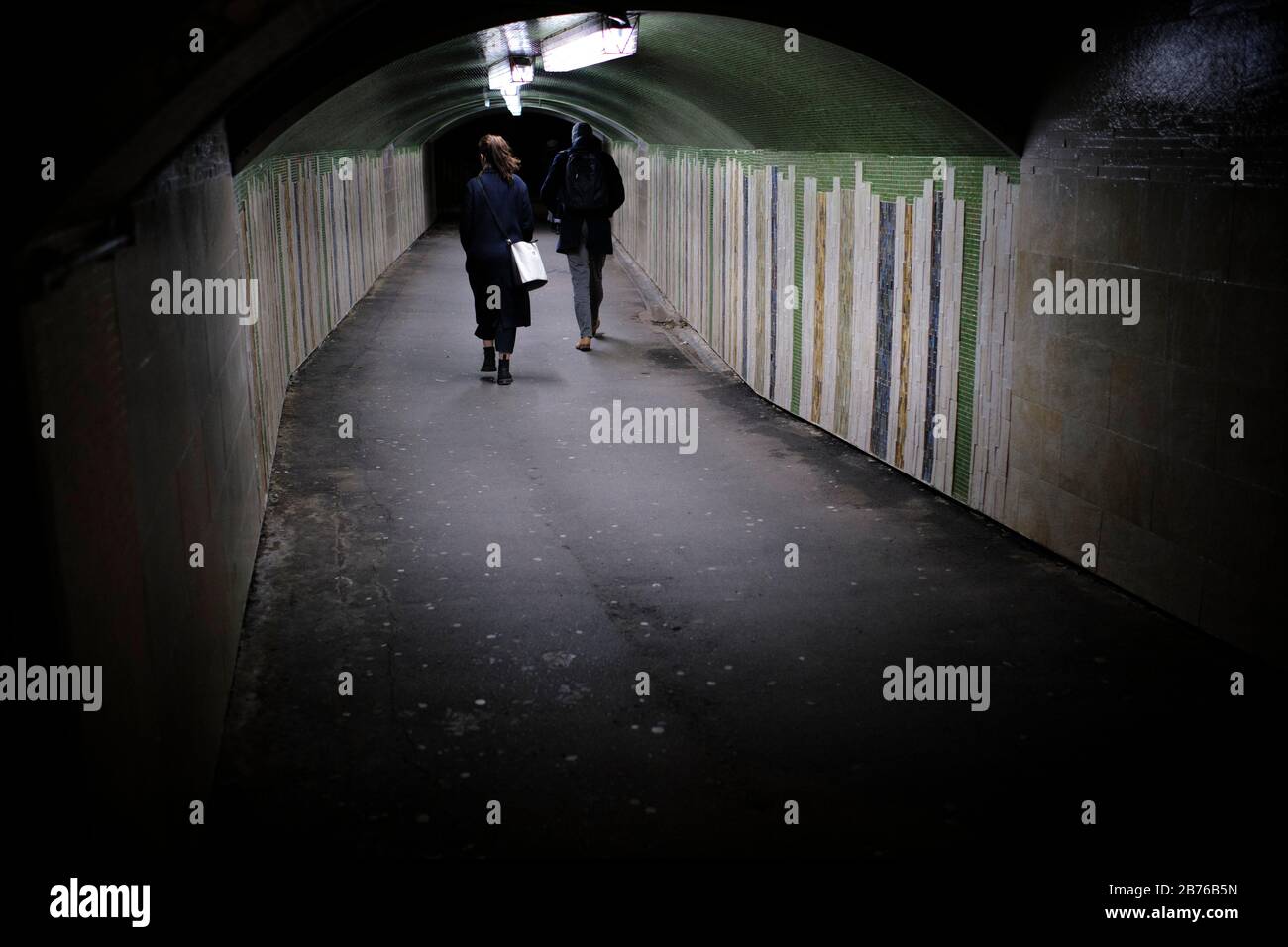 Badly lit pedestrian underpass at night, intimidating urban environment ...
