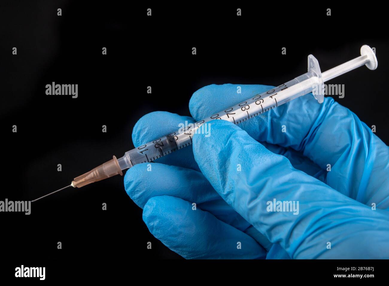 Plastic syringe and needle in hand in medical glove. Medical ...
