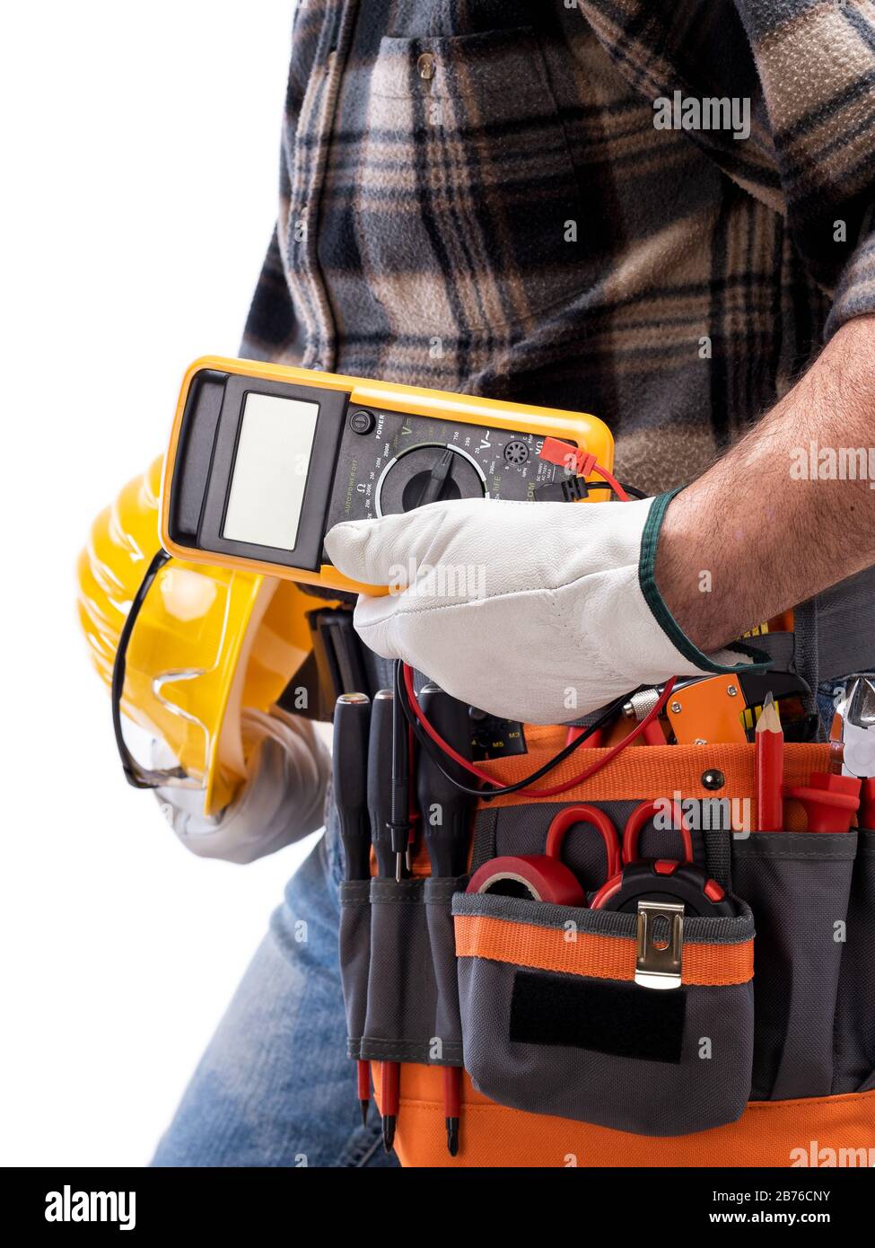 Electrician holds multimeter tester in hand, helmet with protective ...