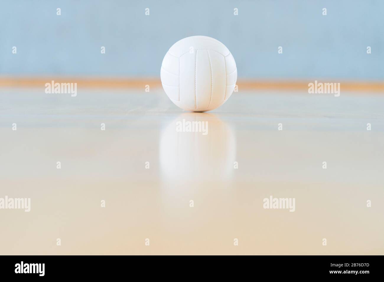 A volleyball and reflection on a wooden floor Stock Photo - Alamy