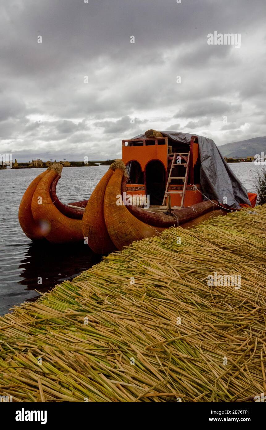 Boat made of totora by the uros with a cloudy sky in a floating Island ...