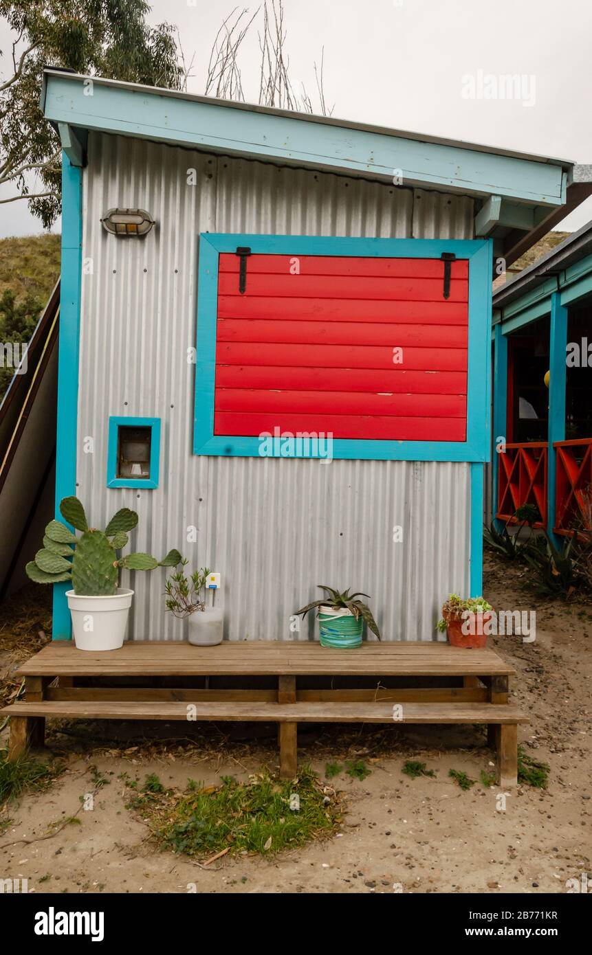 Tin storage house with a red wooden window and light blue moldings and ...