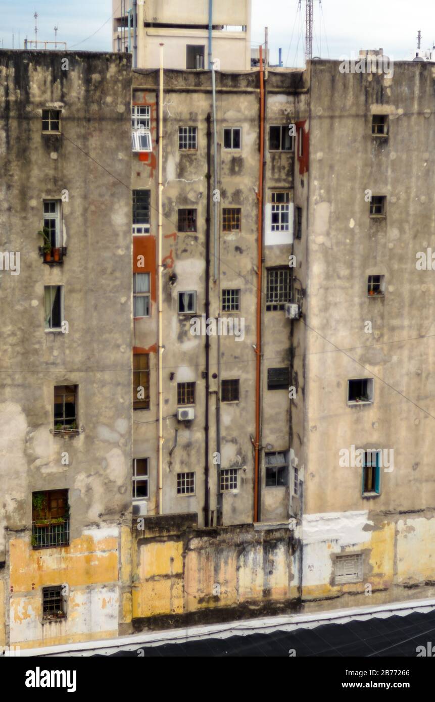 Old and neglected building with a lot of windows, pipes and balconys ...