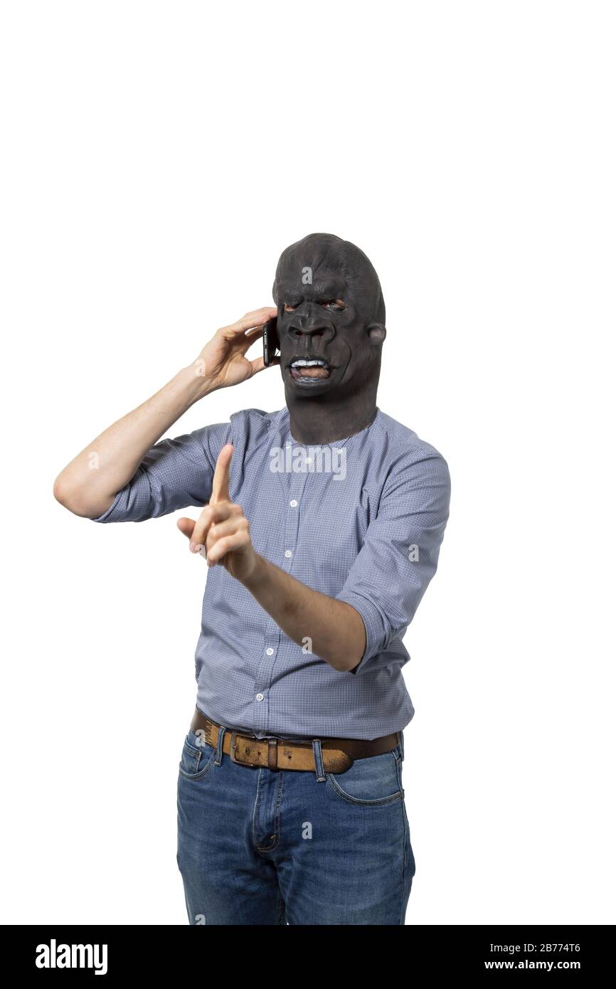 Male in a black angry mask talking on a phone with a raised forefinger ...