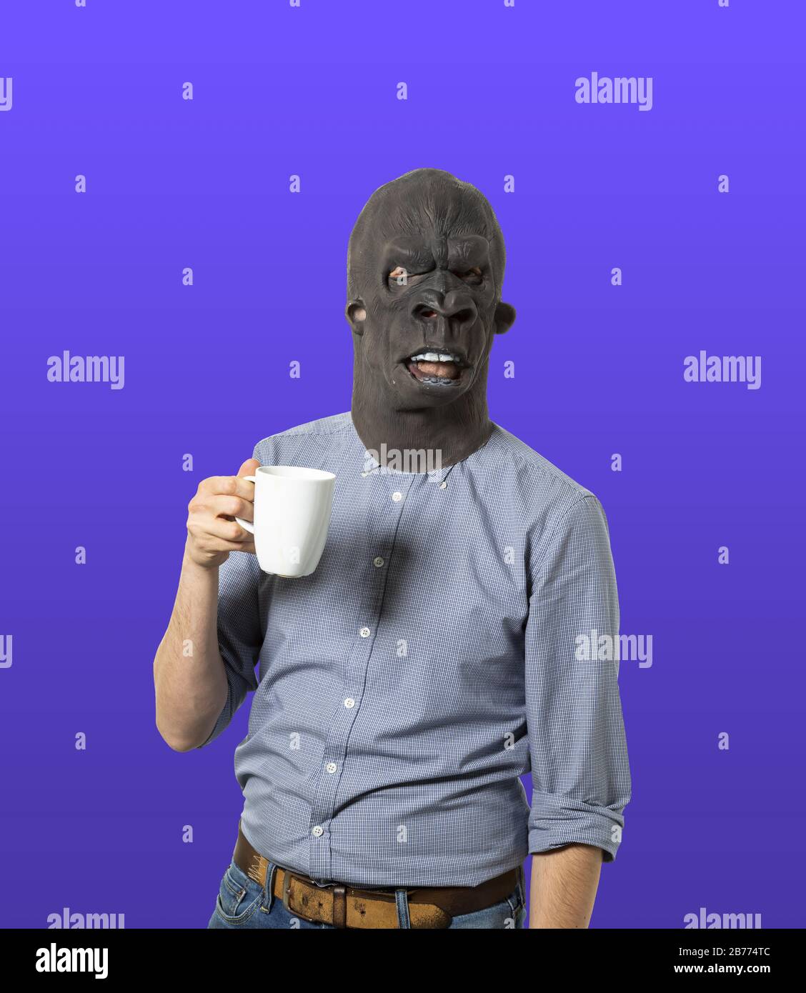 Male in a black angry mask holding a white cup with a purple background ...