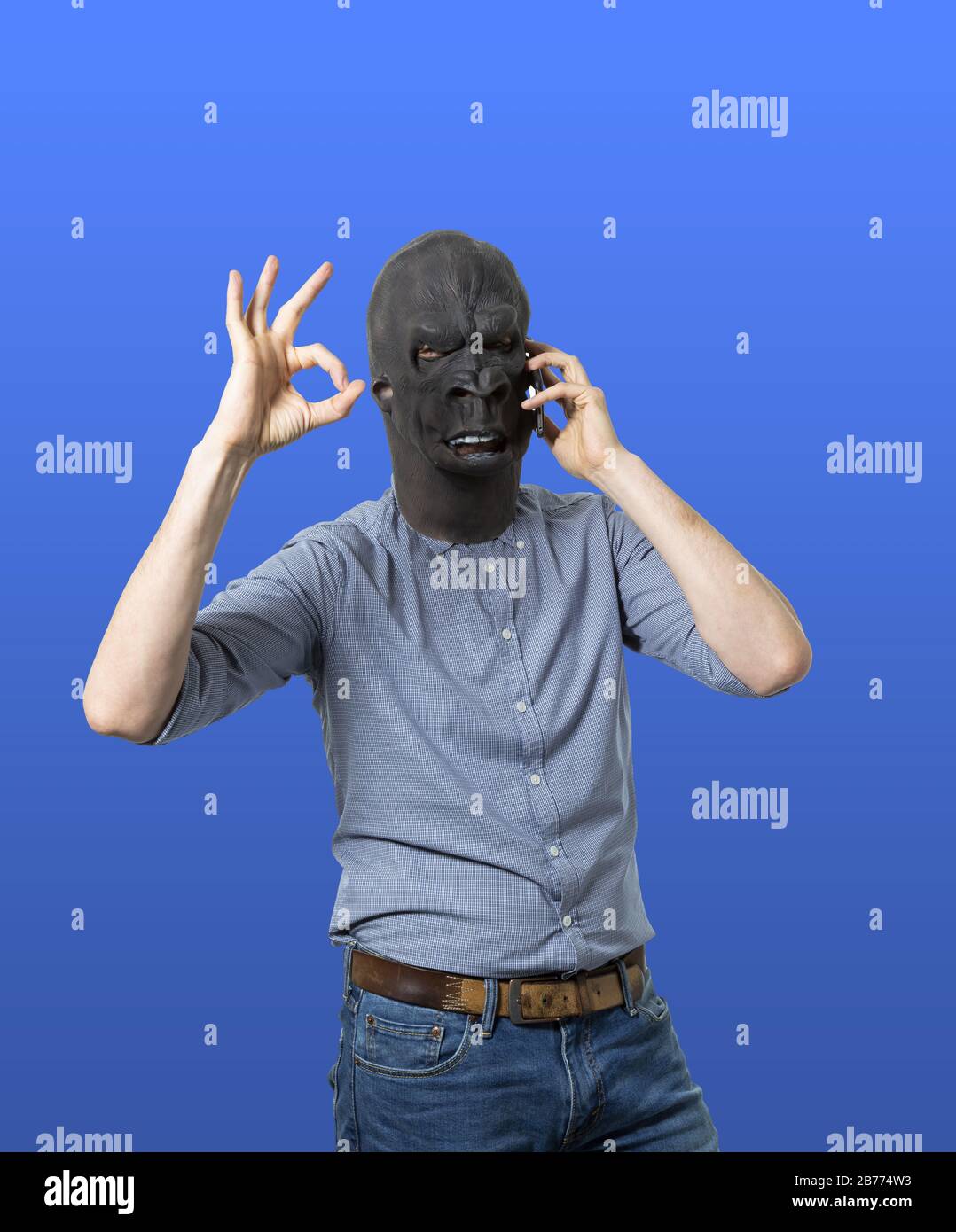 Male in a black angry mask talking on the phone and showing the OK ...