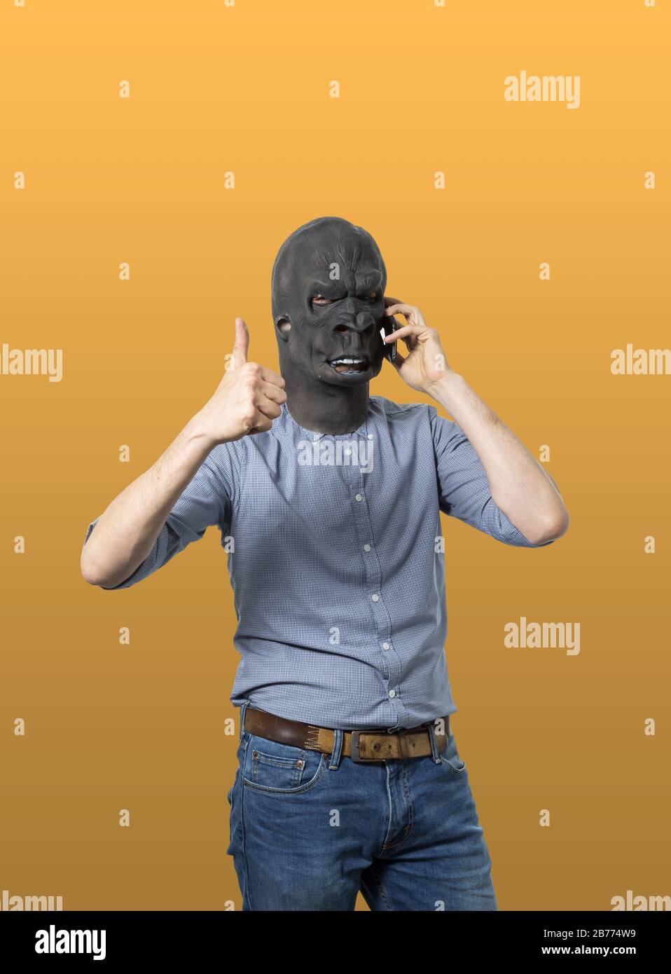 Male in a black angry mask talking on a phone and showing the like sign ...