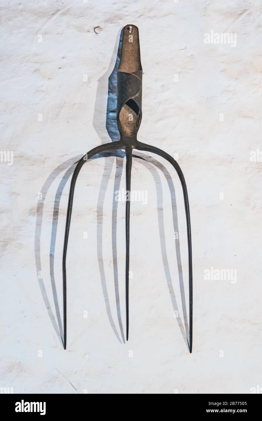 Pitchfork hanging on a white wall Stock Photo - Alamy
