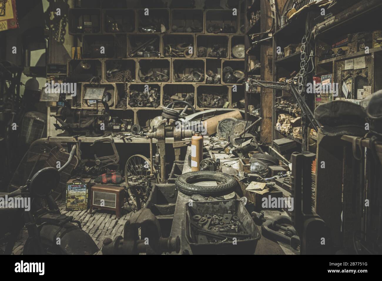 Old dark auto repair shop with wheels and spare parts Stock Photo - Alamy
