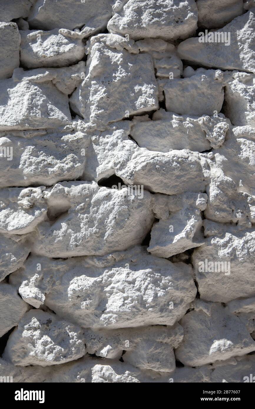 Vertical closeup of a white stone wall under the sunlight at daytime ...