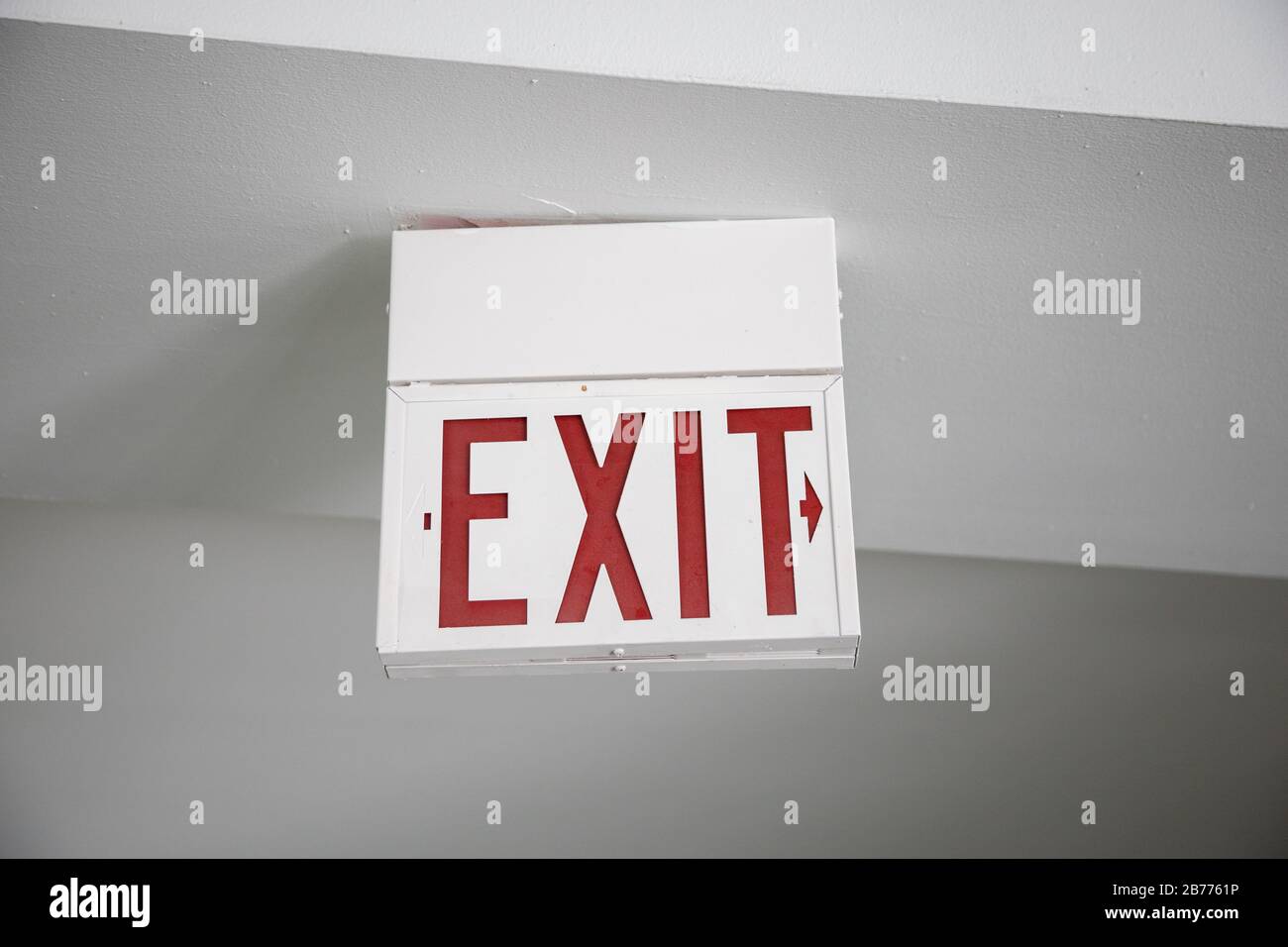 Red and white Exit sign hanging from the ceiling under the lights Stock ...