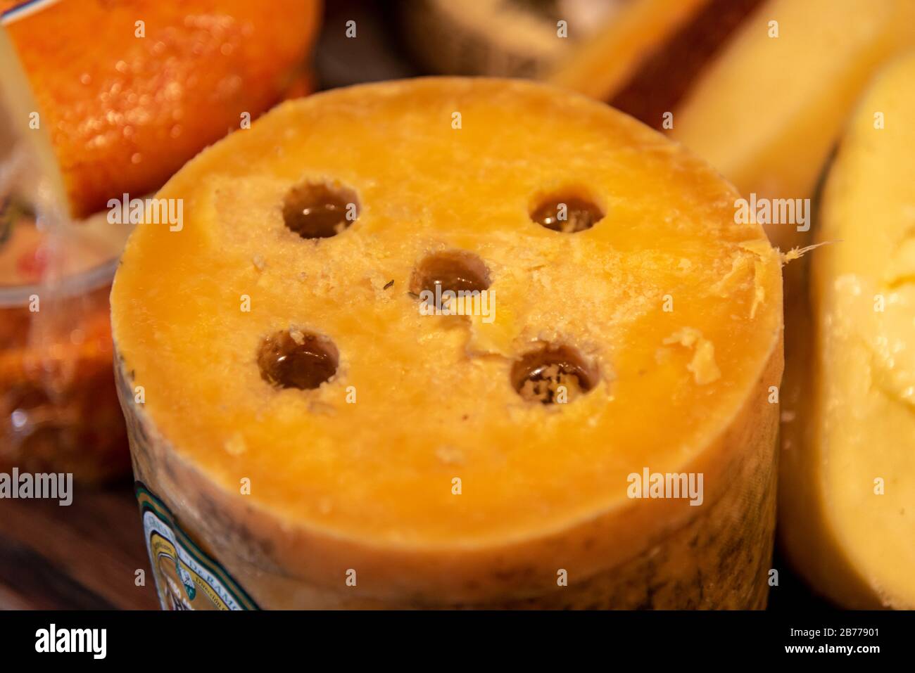Cheddar cheese with five holes with wisky Stock Photo - Alamy