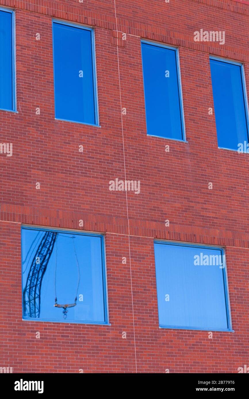 Vertical low angle of a brick building with a lot of mirror windows ...