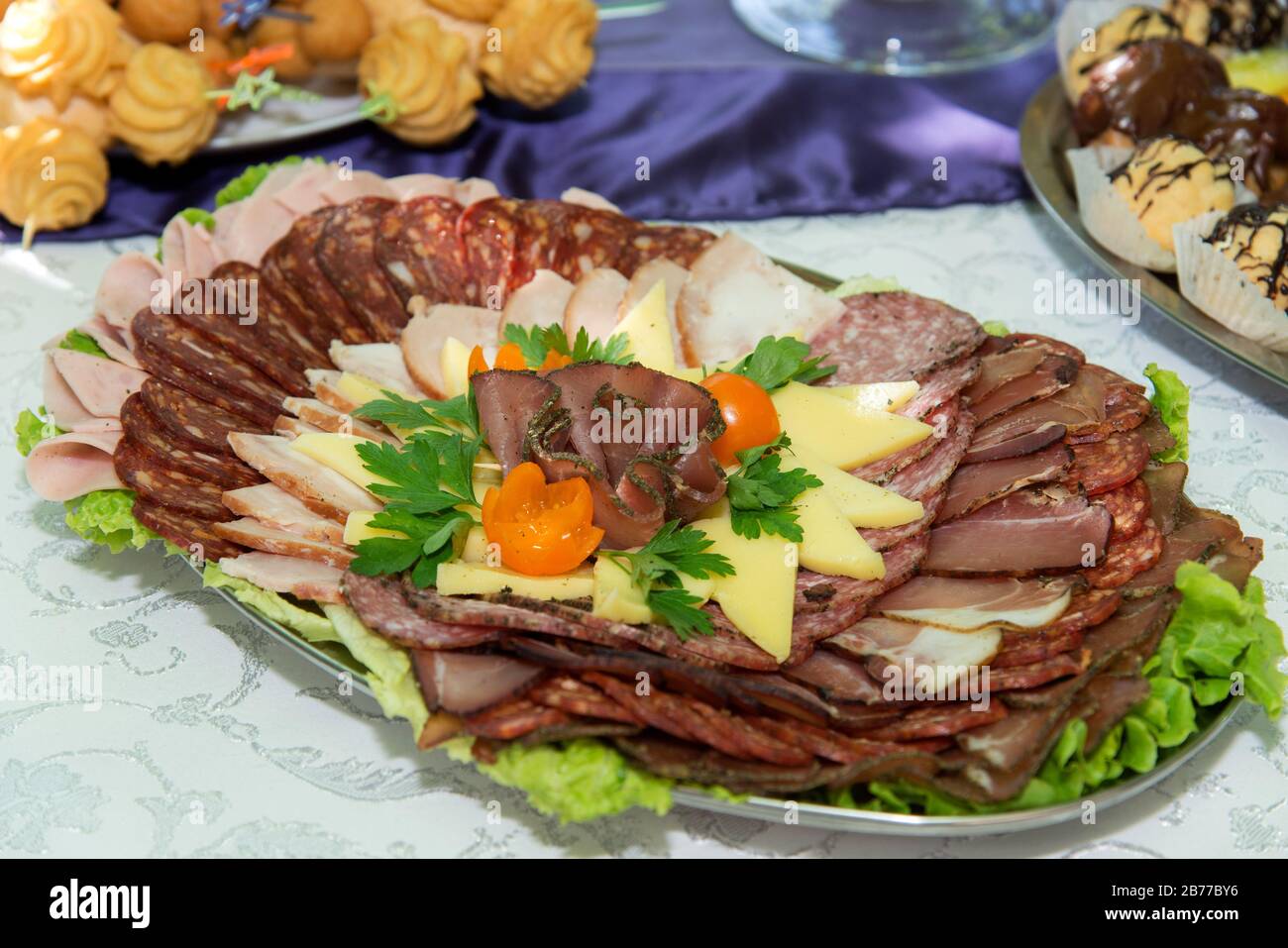 Different types delicacies of meat and cheese arranged in a plate over ...
