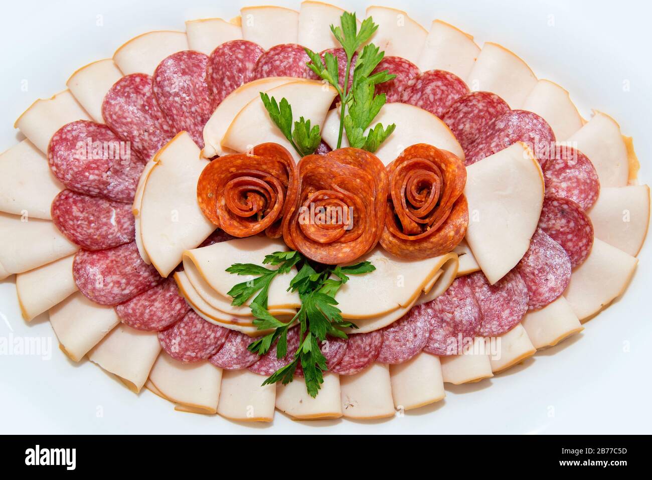 Different types delicacies of meat and cheese arranged in a plate over ...