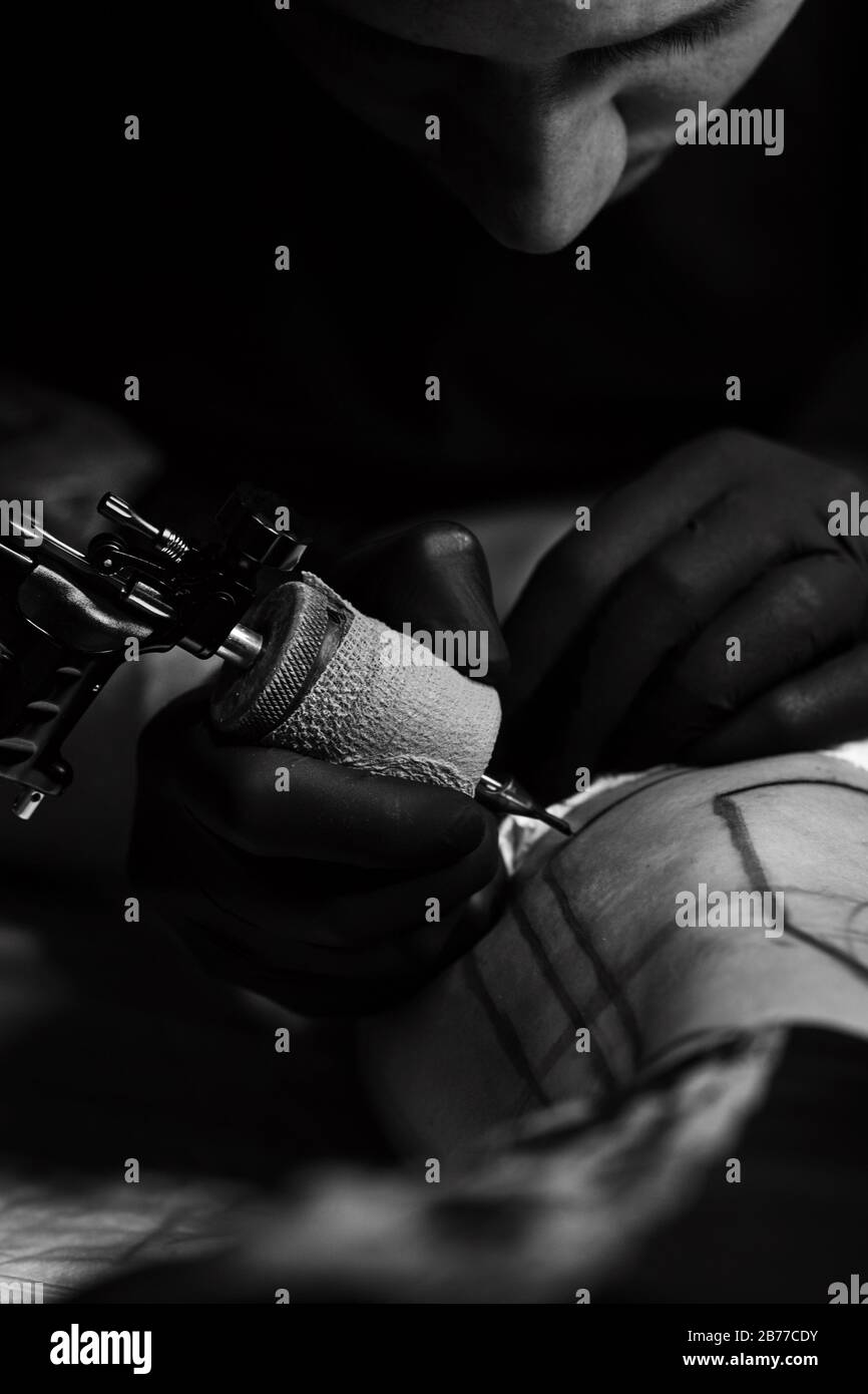 Process of making tattoo close-up. Professional tattoo artist makes ...