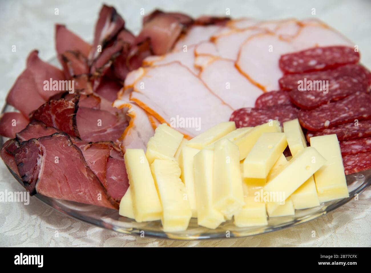 Different types delicacies of meat and cheese arranged in a plate over ...
