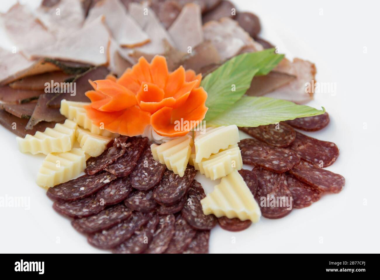 Different types delicacies of meat and cheese arranged in a plate over ...