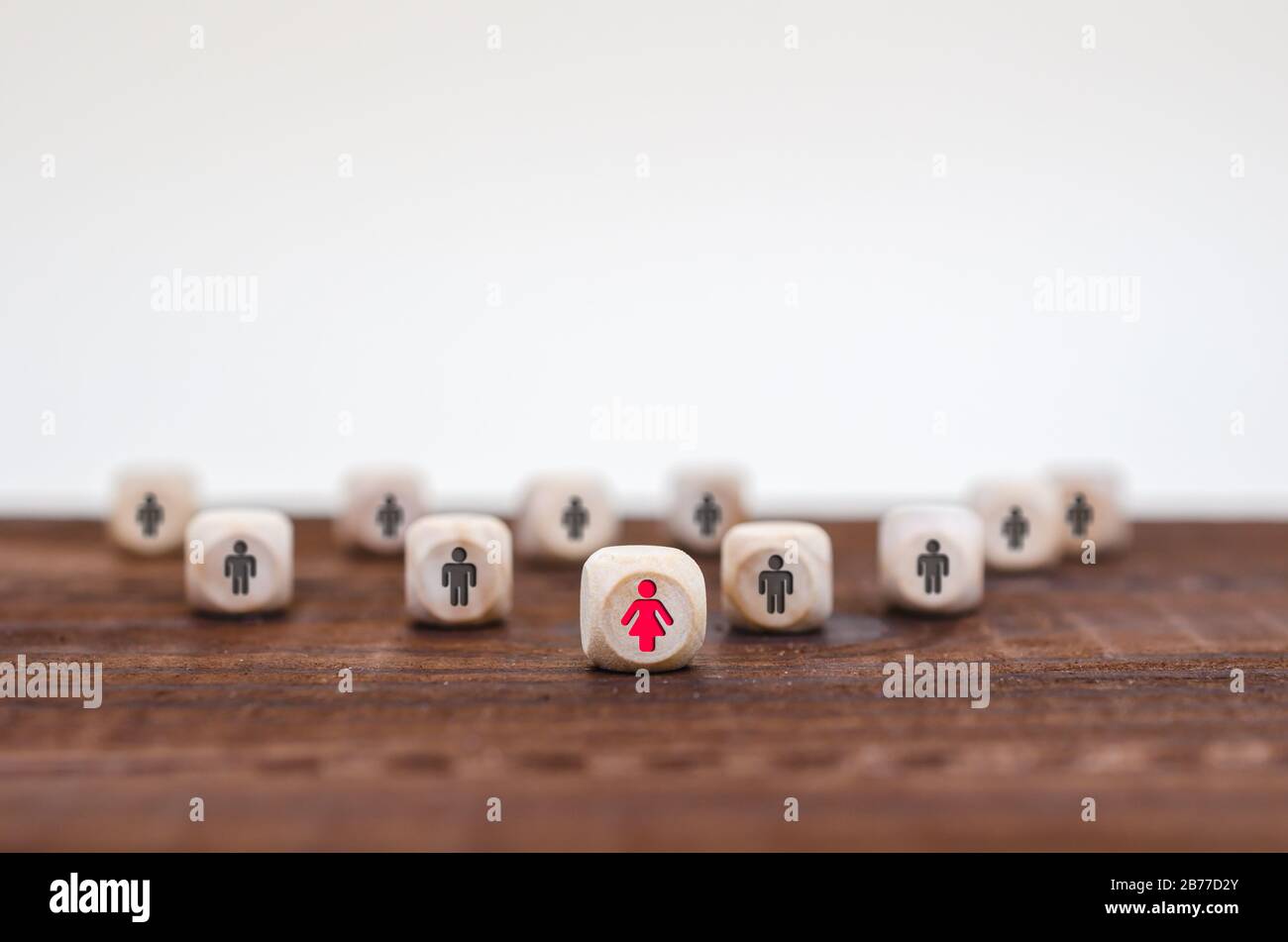 Wooden cube blocks with icon people standing out from the crowd with a ...