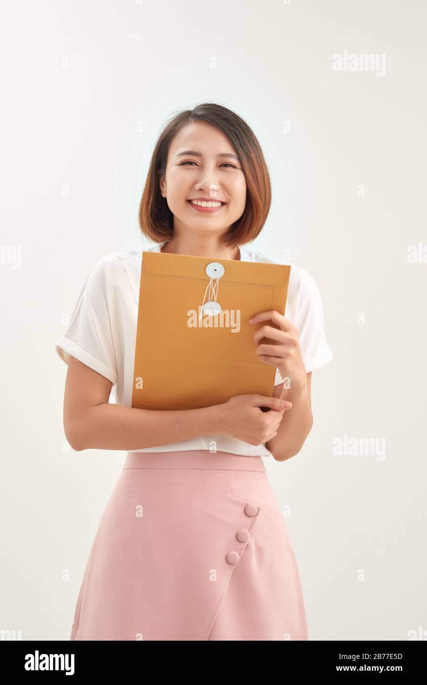 Woman hand holding brown envelope on white background Stock Photo - Alamy