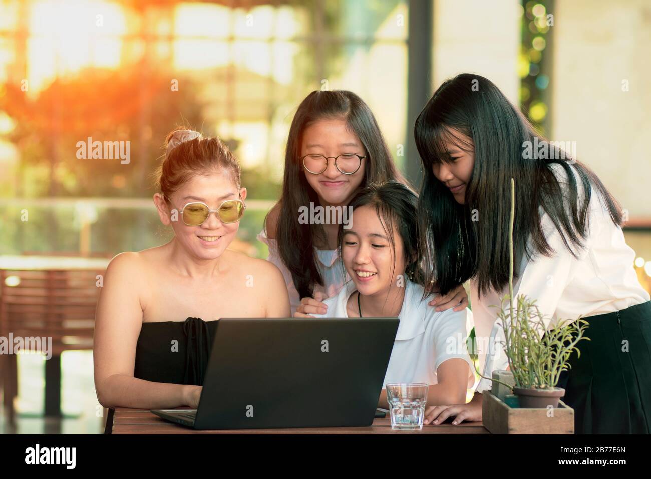 asian woman and teenager working on computer laptop in living room ...