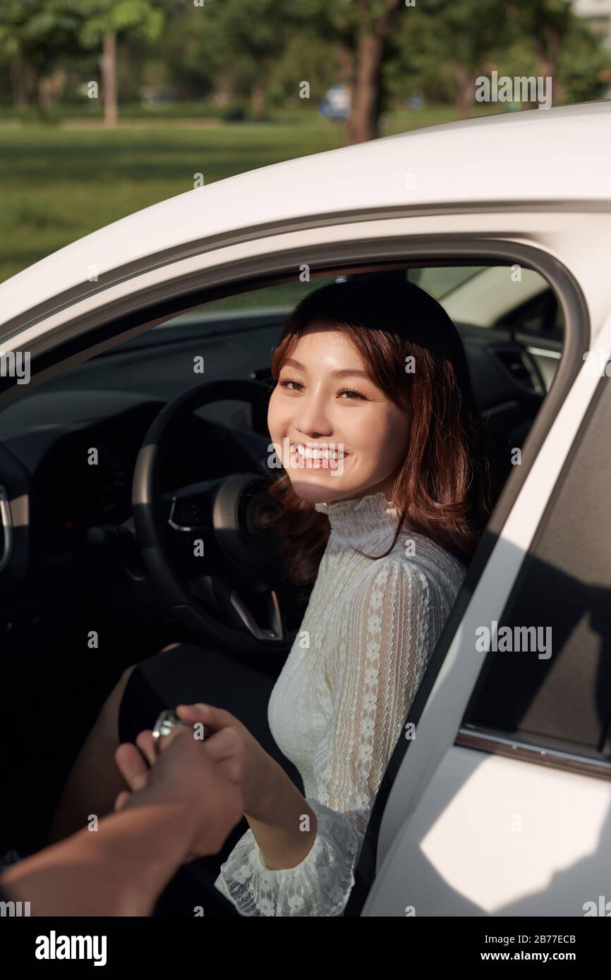 Young smiling woman getting keys of a new car. Concept for car rental ...