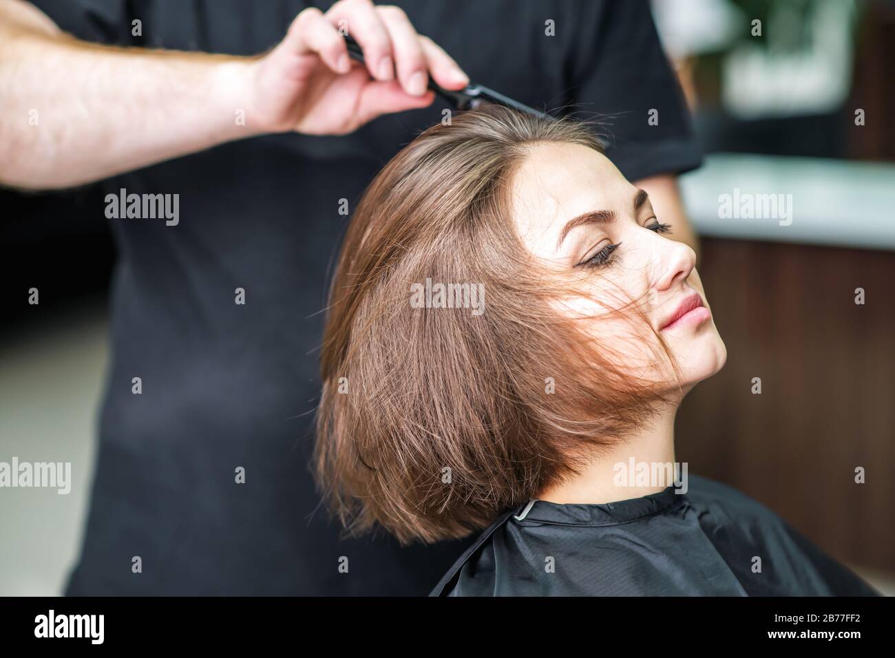 Hairdresser combs hair of woman at hair salon Stock Photo - Alamy