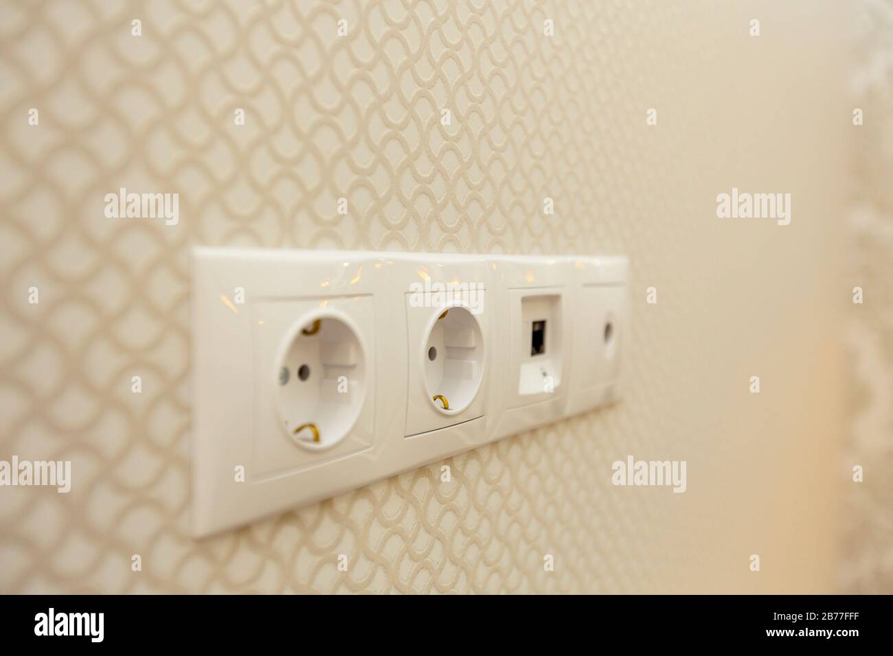 three electrical outlets on the wall against a background of sand ...