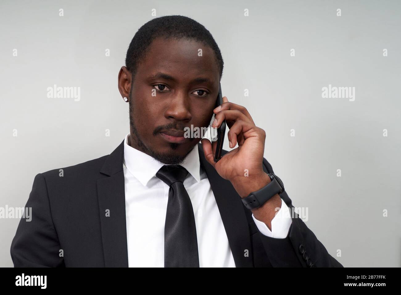 Closeup of angry young african man screaming while talking on ...