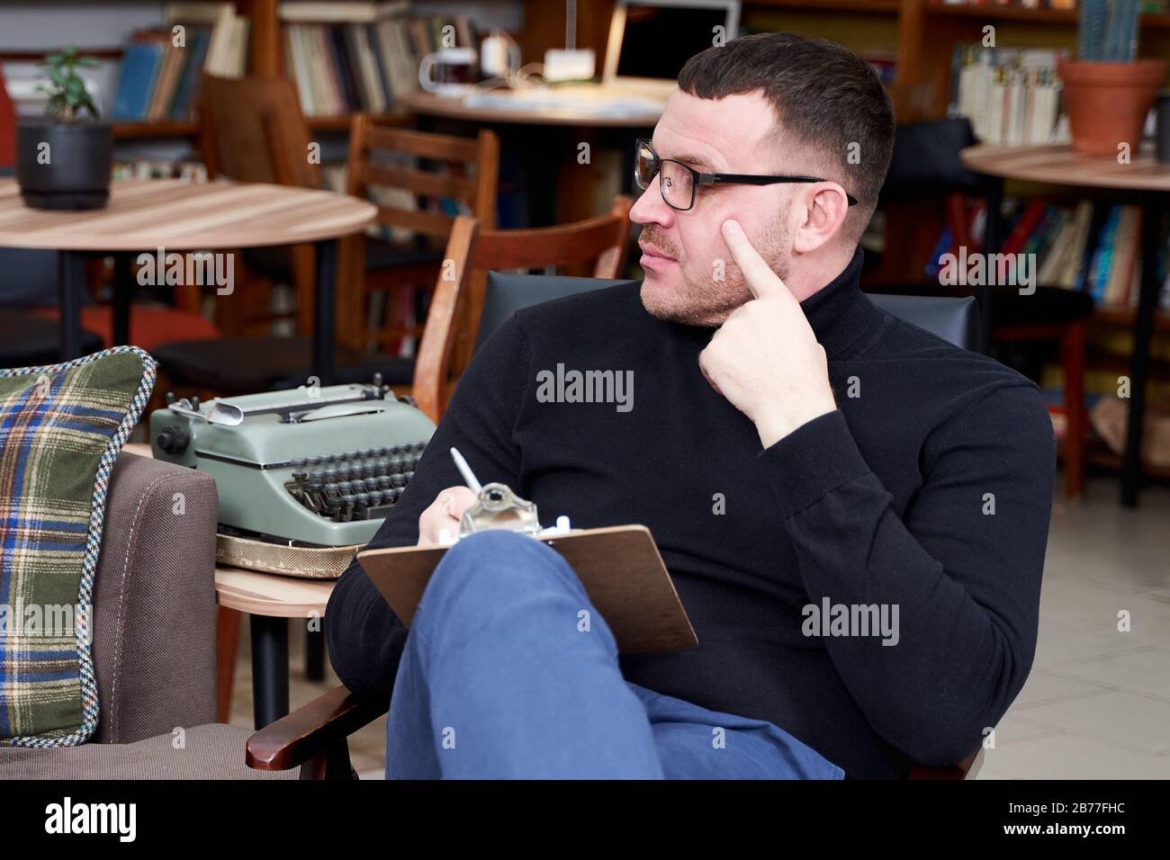 Therapist writing down notes during therapy sitting in a chair Stock ...