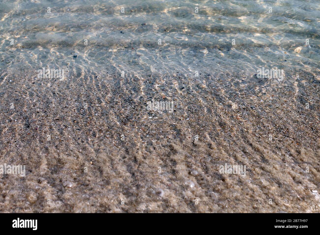 Surface water wave on the sand close up, Wave of the sea on the sand ...