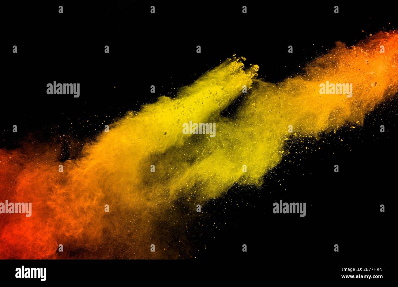 Abstract yellow orange powder explosion on white background. Freeze ...