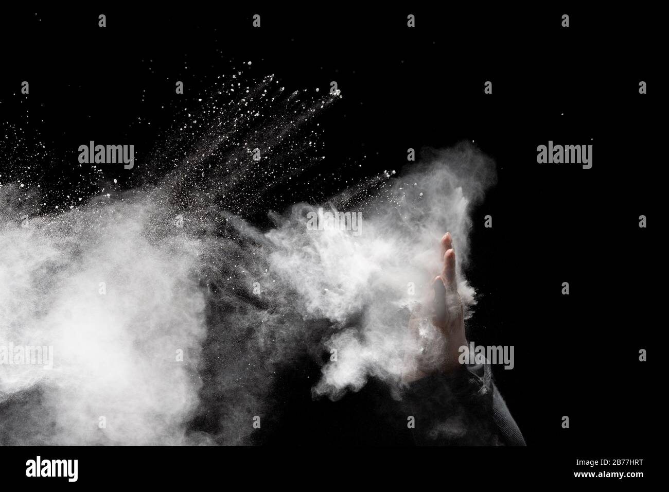 Hand throwing podwer up to the air.Freeze motion of white dust ...
