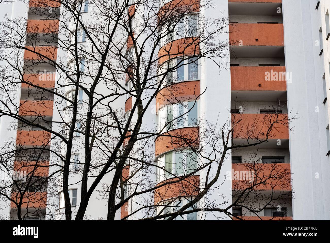 Modern tall apartment building and tree branches Stock Photo - Alamy