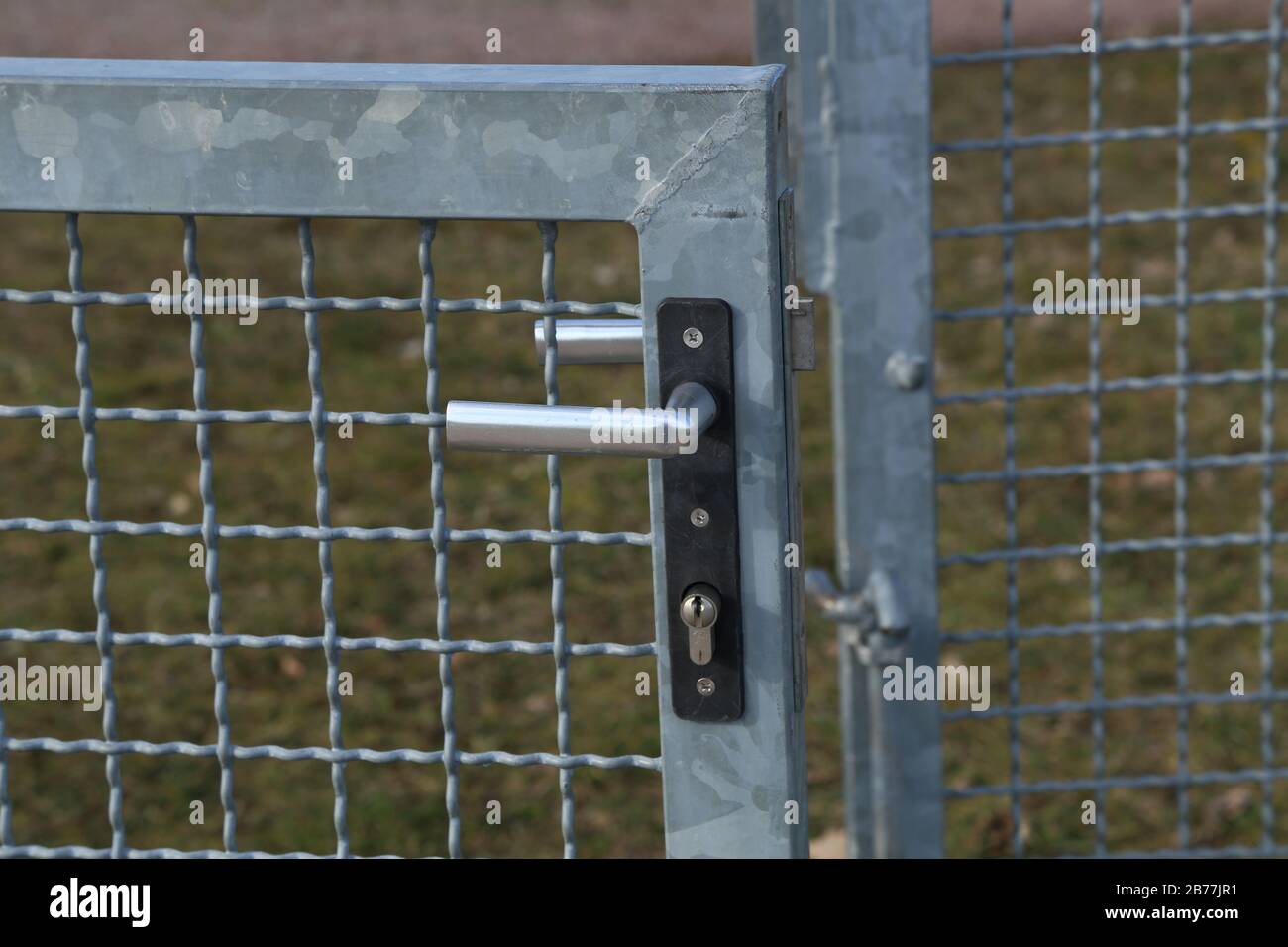 Metal mesh gate with internal lock and handle Stock Photo - Alamy