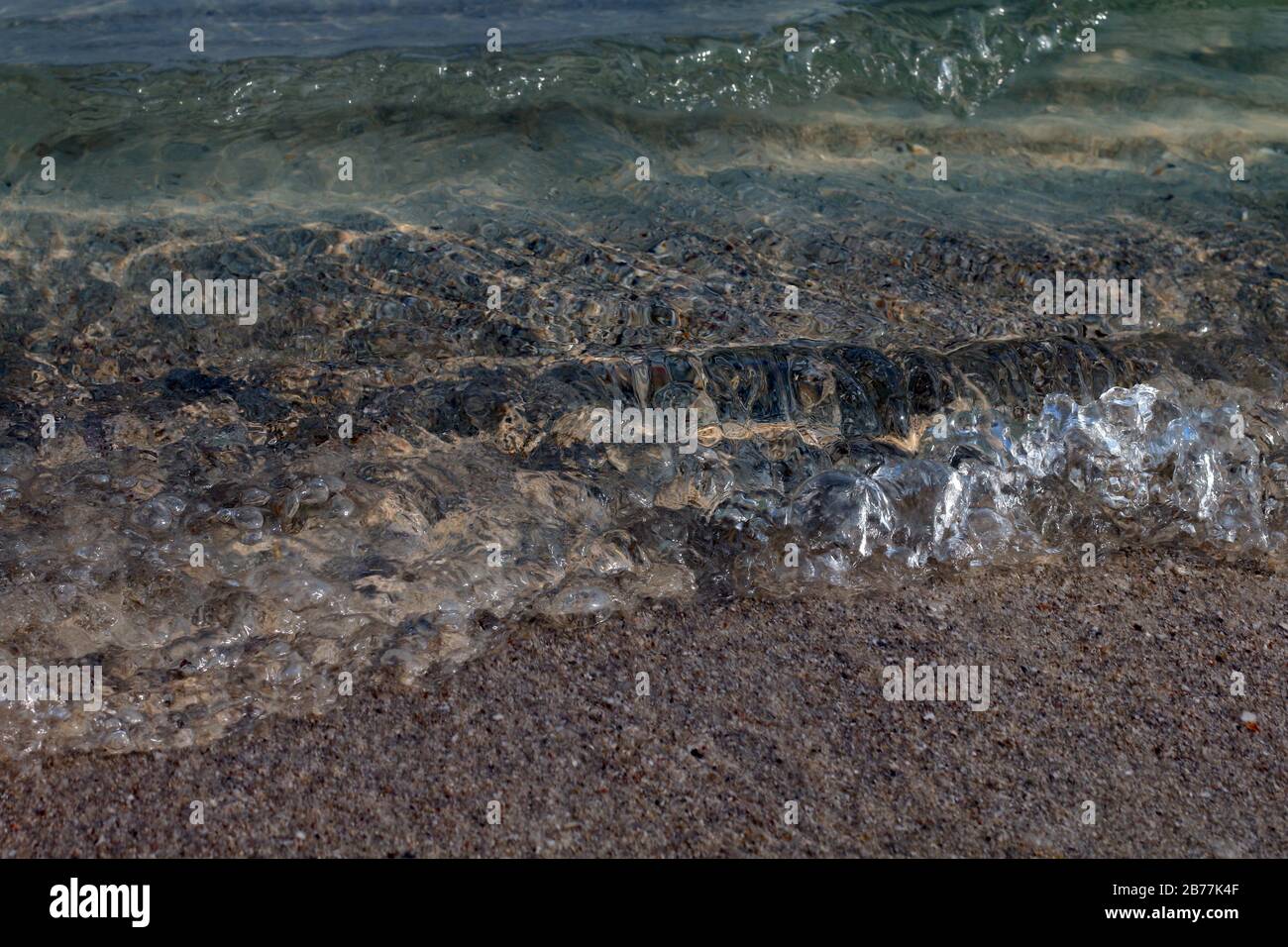 Surface water wave on the sand close up, Wave of the sea on the sand ...