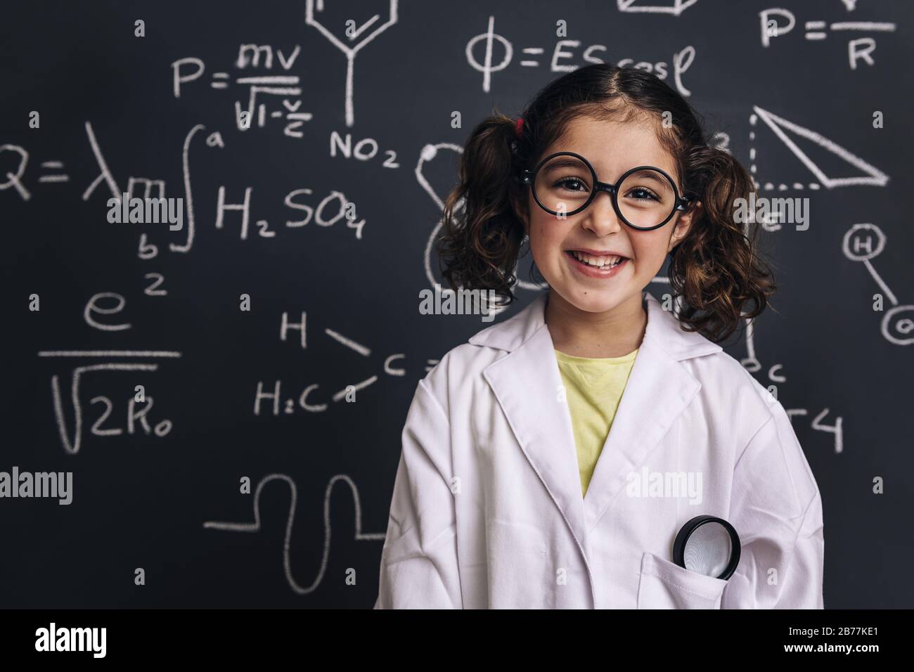 smiling little girl science student with glasses in lab coat on school ...